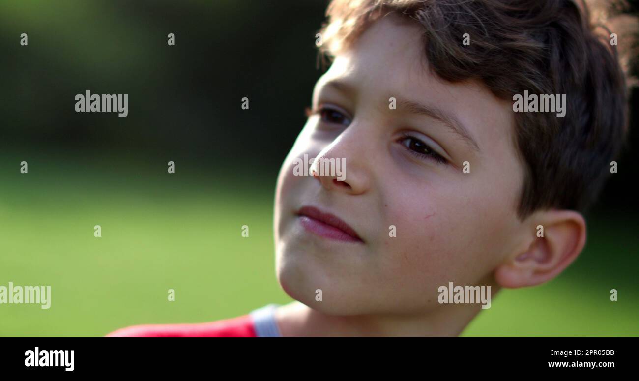 Contemplative pensive child outside during sunny day. Thoughtful kid ...