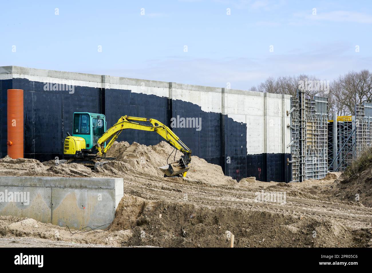 Concrete wall built using concrete formwork, partly covered with ...