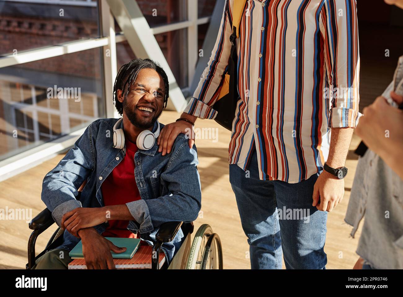 African American student with disability talking to his classmates ...