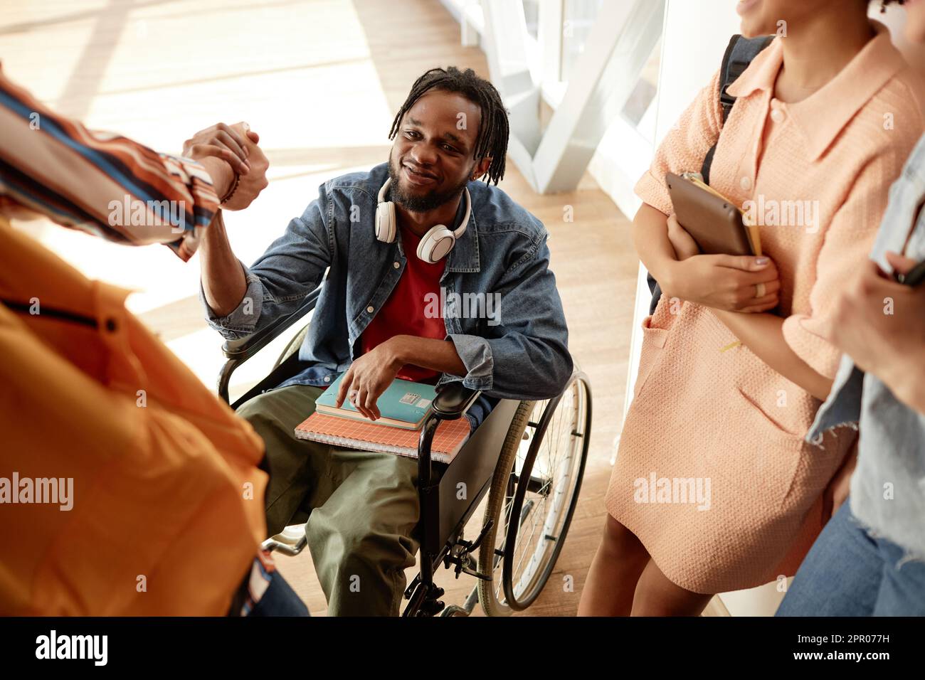 African American student with disability sitting on wheelchair and ...