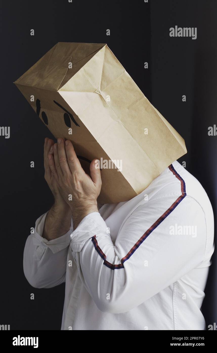 A sad man in a white shirt with a bag on his head, with a drawn crying ...