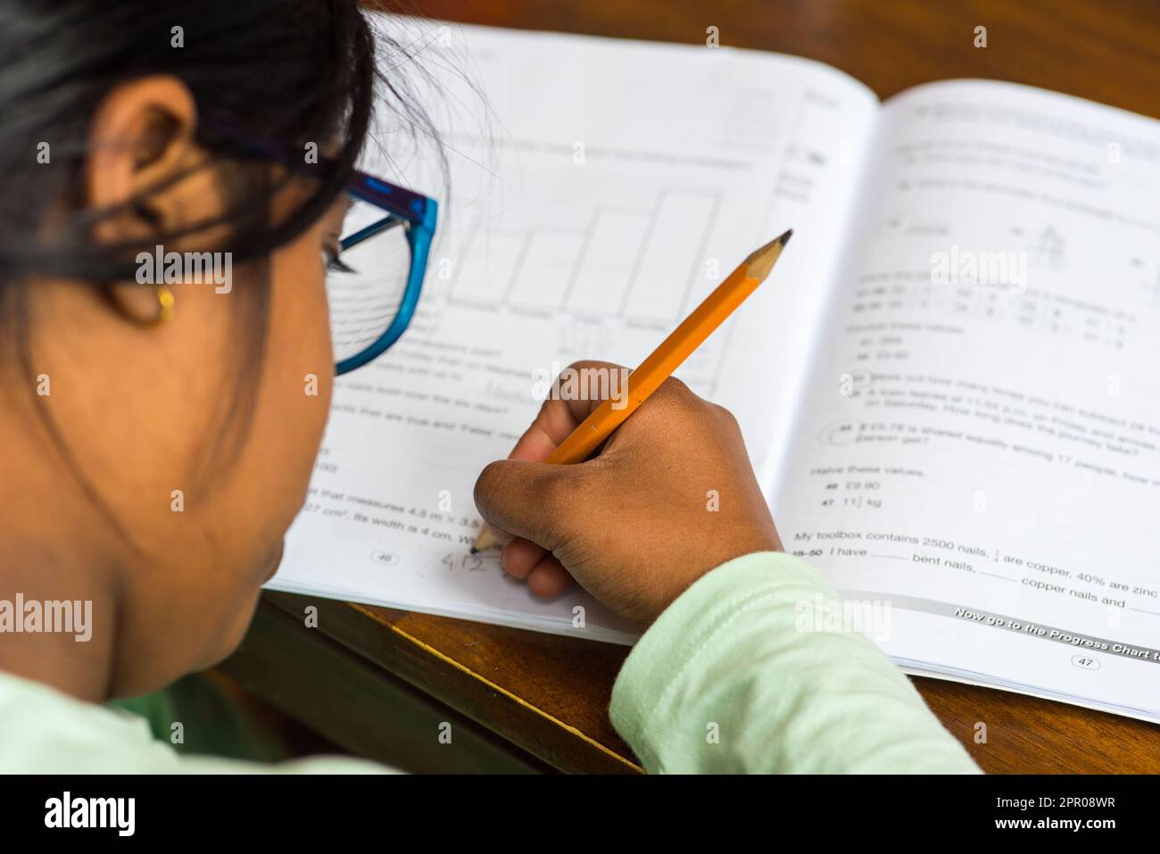 Young girl child writing with pencil Stock Photo - Alamy
