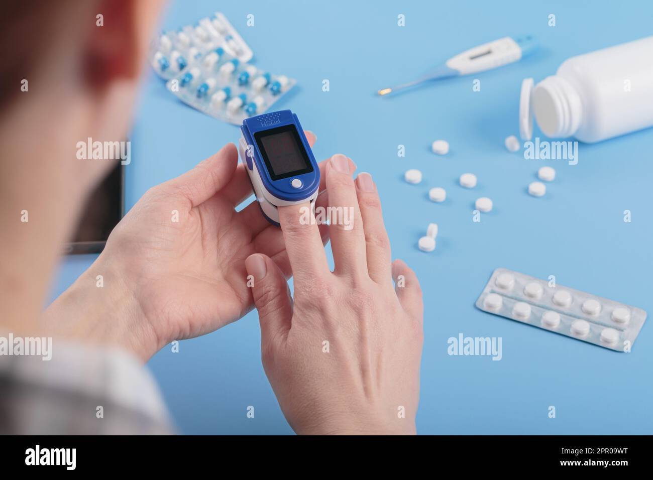 Woman self testing for blood oxygen levels from pulse oximeter Stock ...