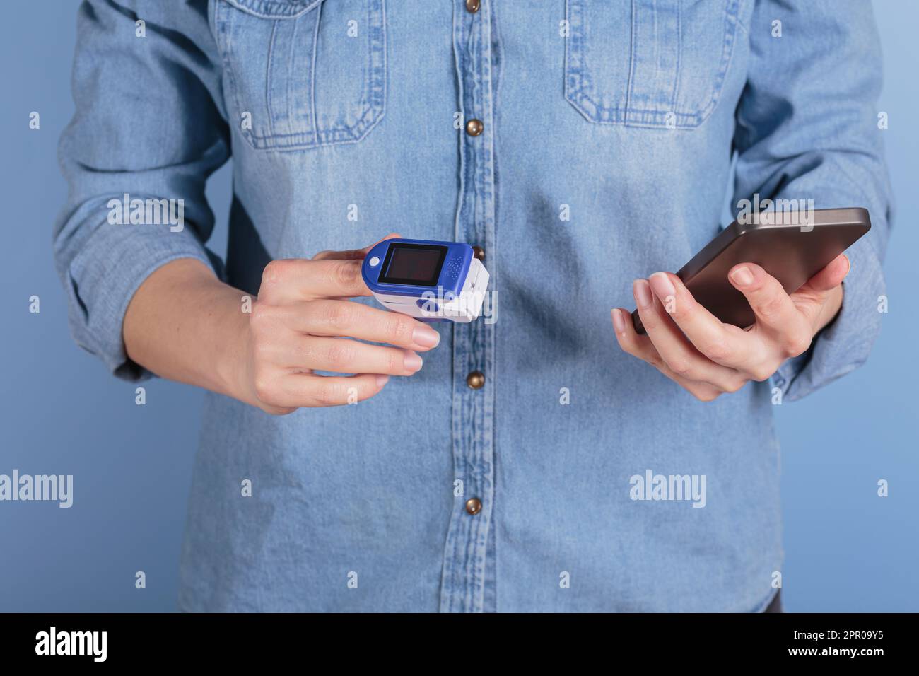 Woman self testing for blood oxygen levels from pulse oximeter Stock ...