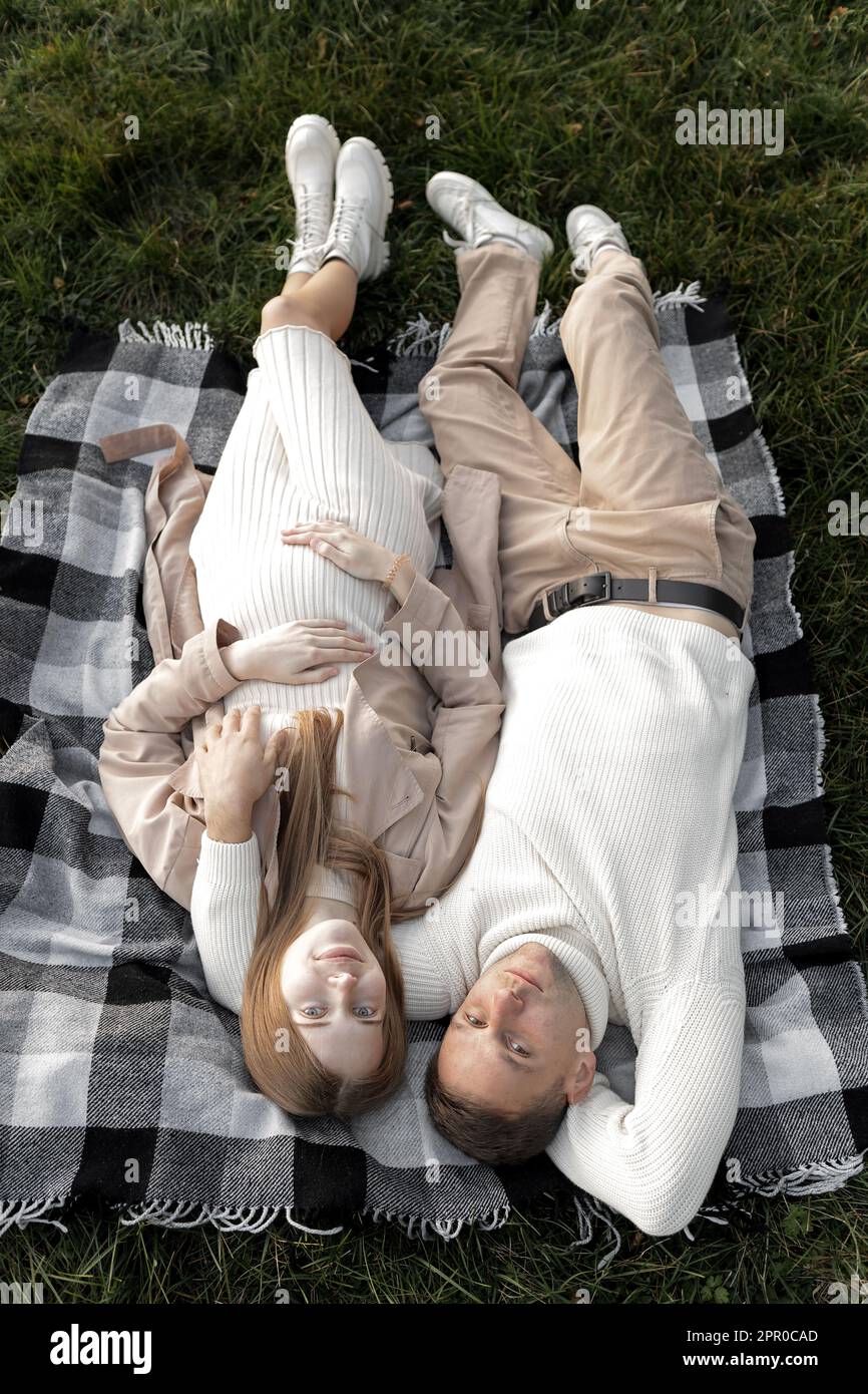 Happy family day. Top view of man and pregnant wife embrace and lie on ...