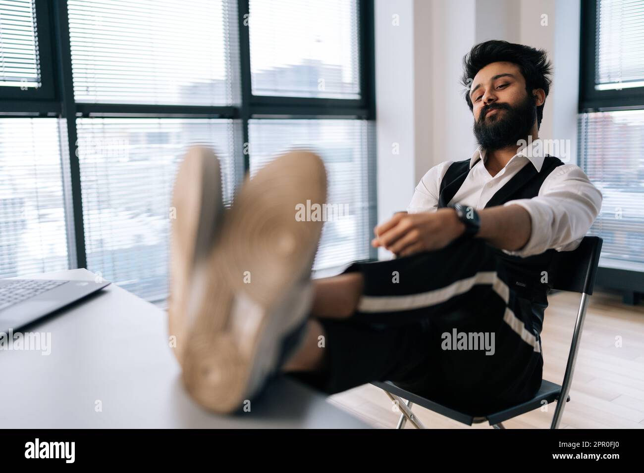 Portrait of confident Indian businessman sitting at office desk with ...