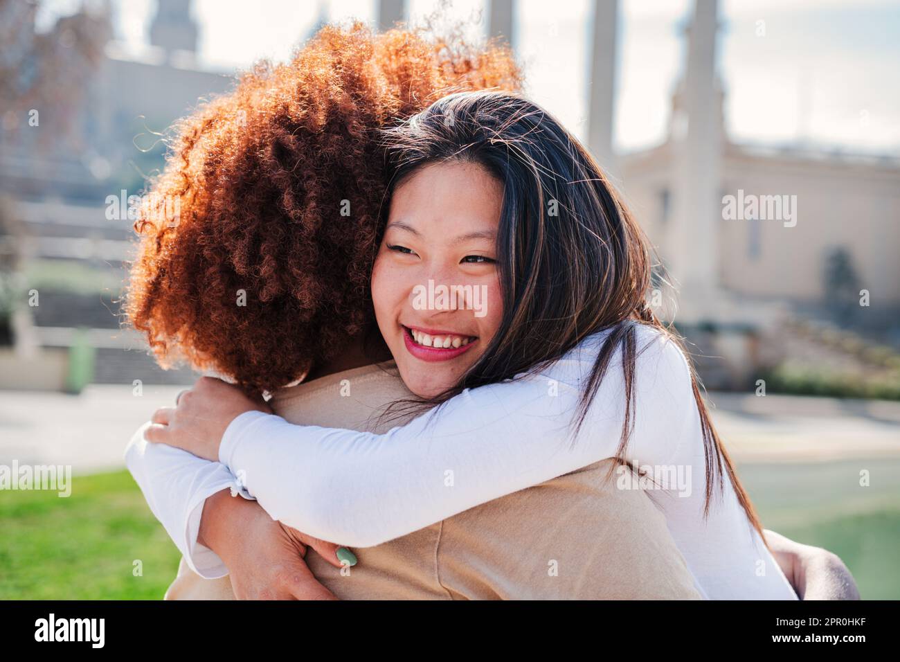 One chinese young woman embracing her friend. A couple giving each ...