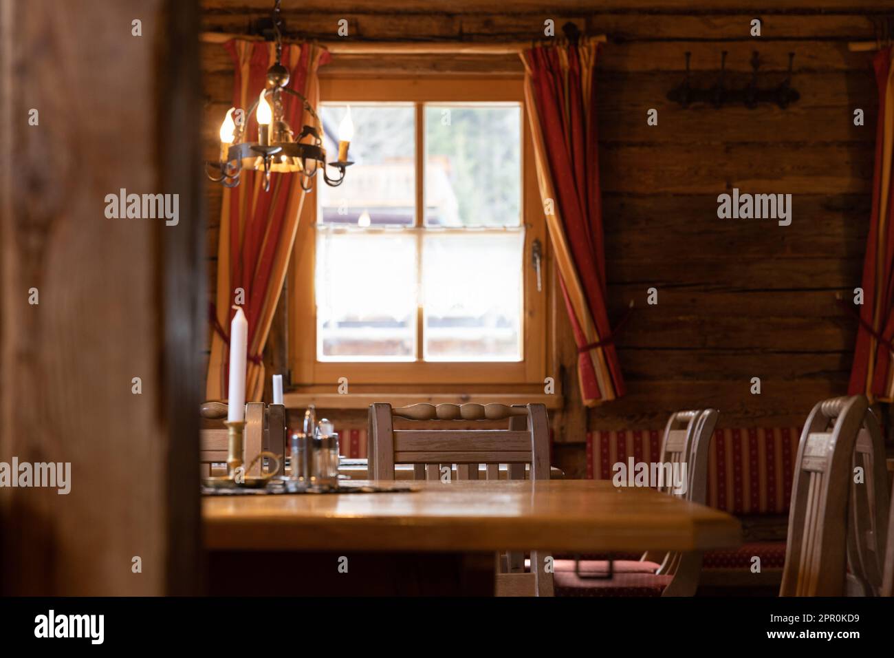 A distant view of a lighted window in a rustic restaurant in Austria ...