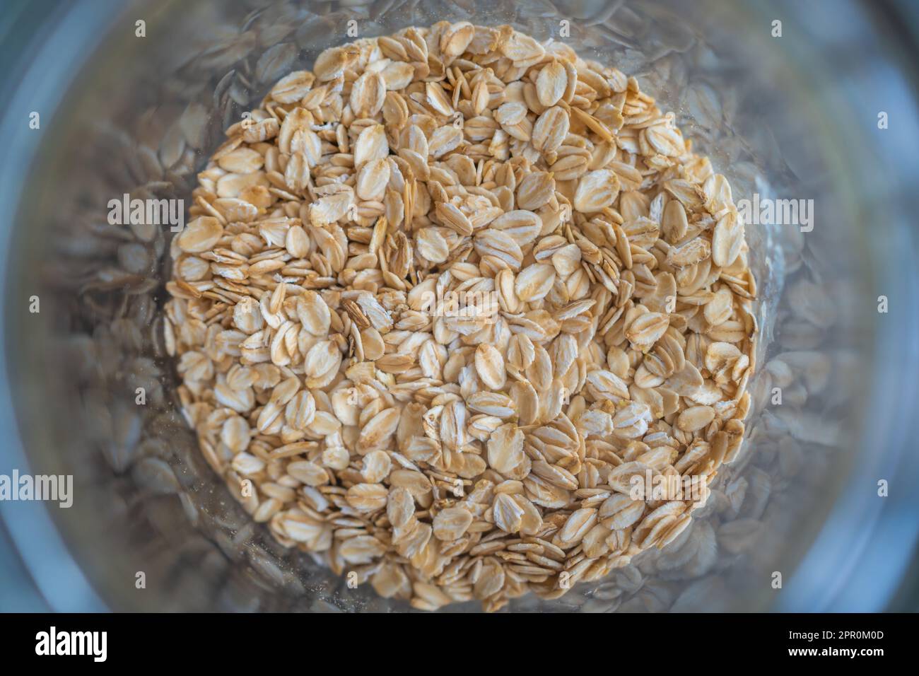 Rolled oats in a glass bowl - top view. On a grey background Stock ...