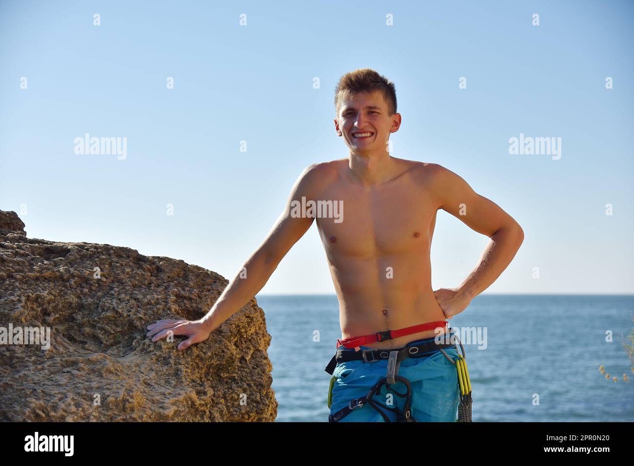 Happy climber man on a sea background Stock Photo - Alamy
