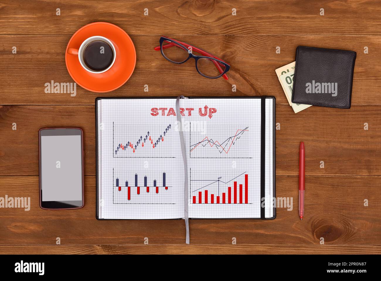 Start up statistics drawing in note pad and business elements on desk ...