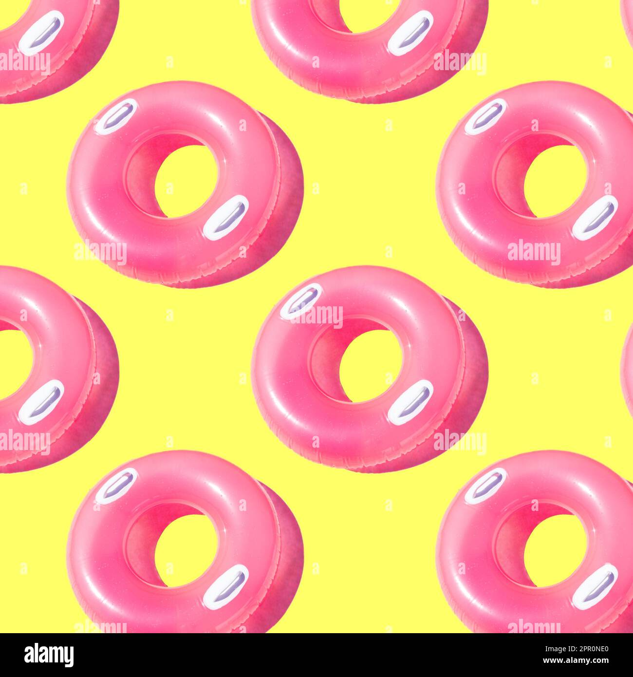 Bright pink inflatable circle with white handles and a shadow on a ...