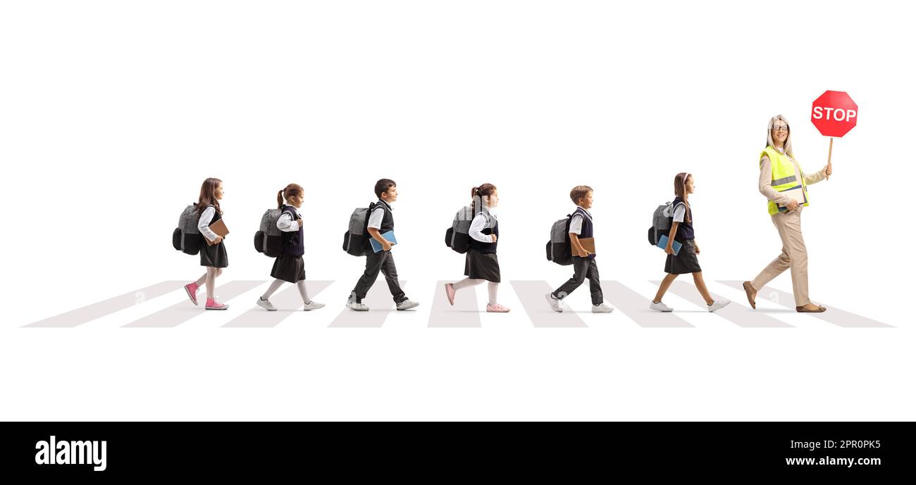 Full length profile shot of a teacher with stop sign and schoolchildren ...
