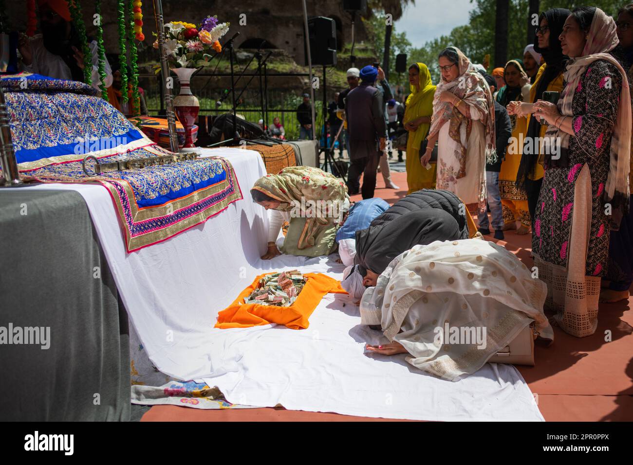 Sikh men and women prostrate in front of the Granth Sahib and Golak ...