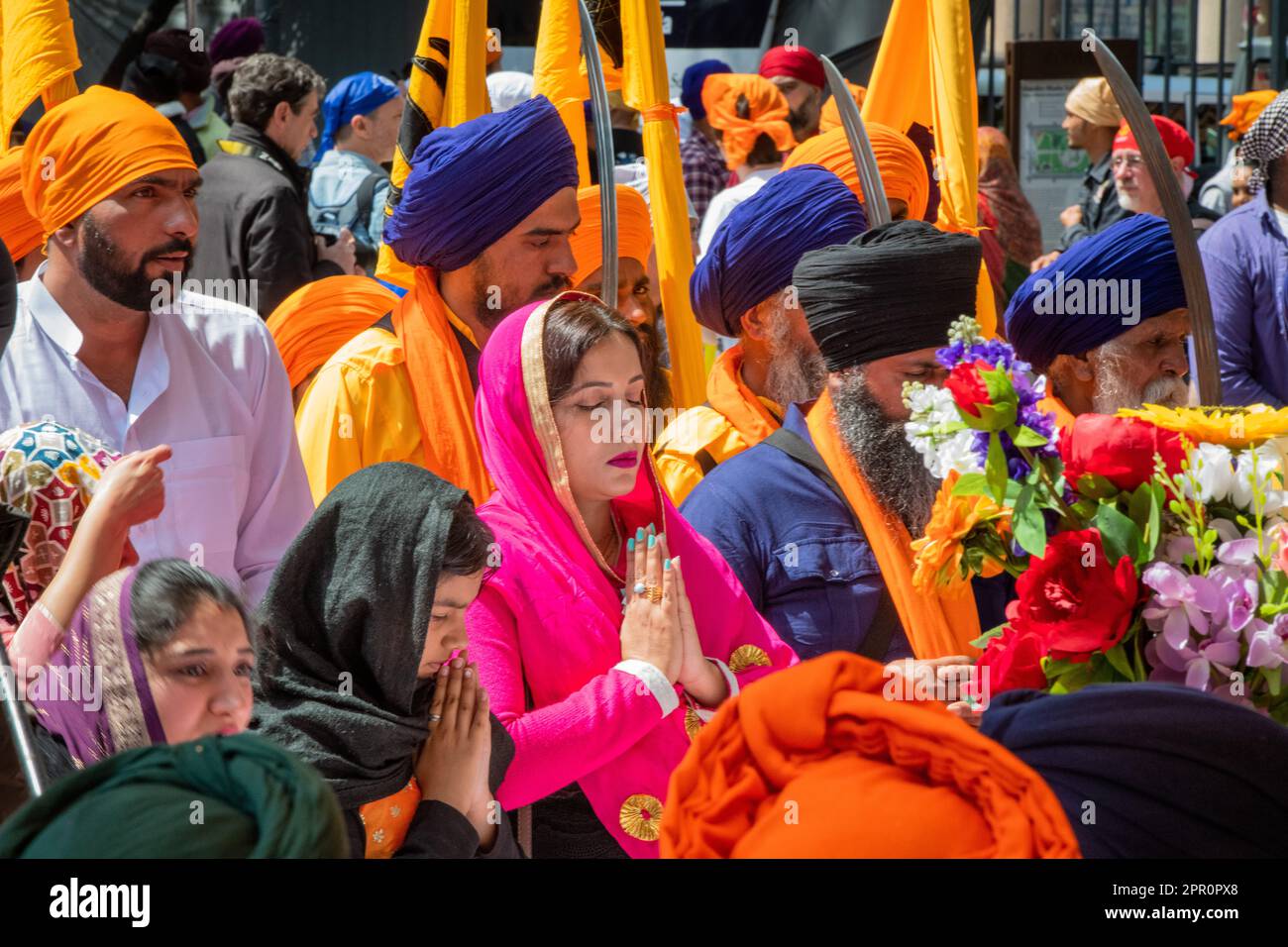 A Sikh woman in traditional clothing prays during the procession for ...