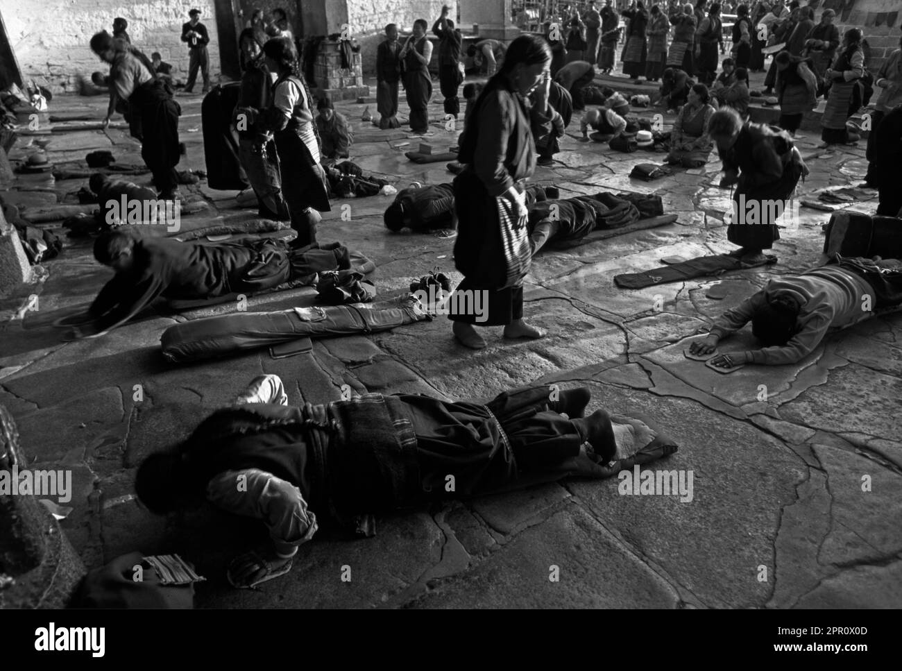 Devout BUDDHISTS prostrate in front of the JOKHANG, TIBET'S holiest ...