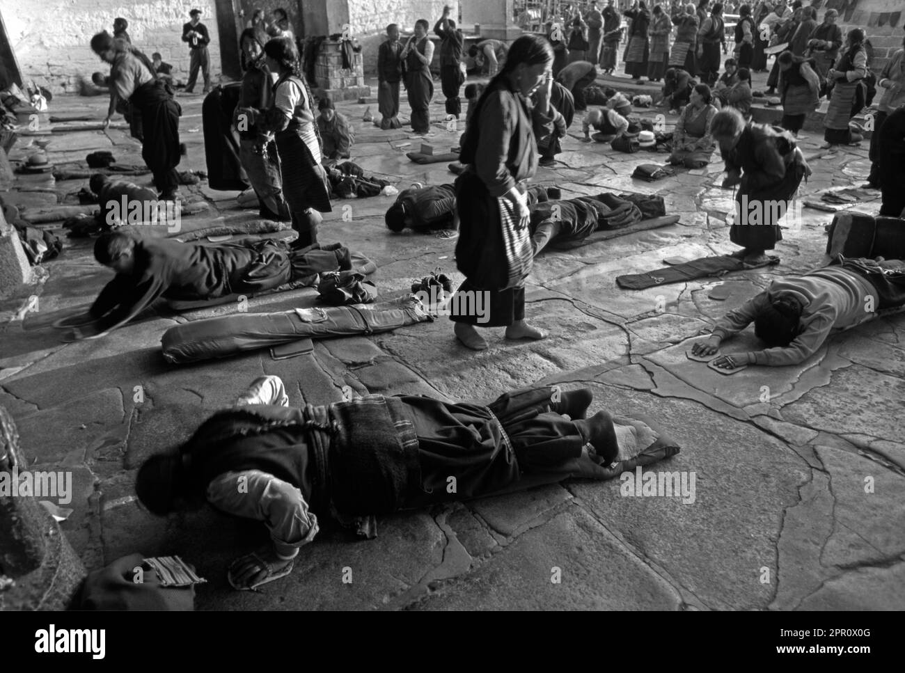 Devout BUDDHISTS prostrate in front of the JOKHANG, TIBET'S holiest ...