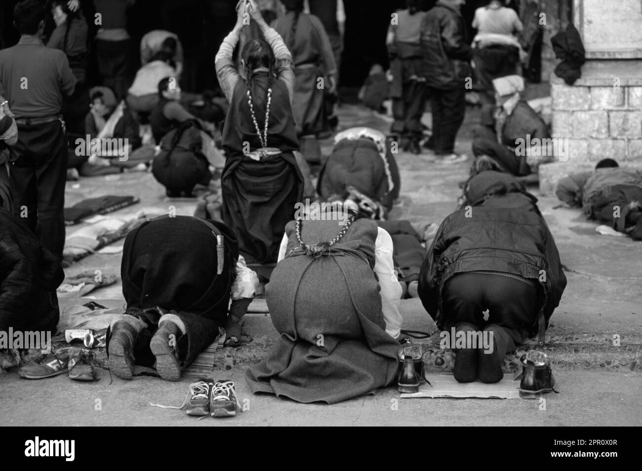 Devout BUDDHISTS prostrate in front of the JOKHANG, TIBET'S holiest ...