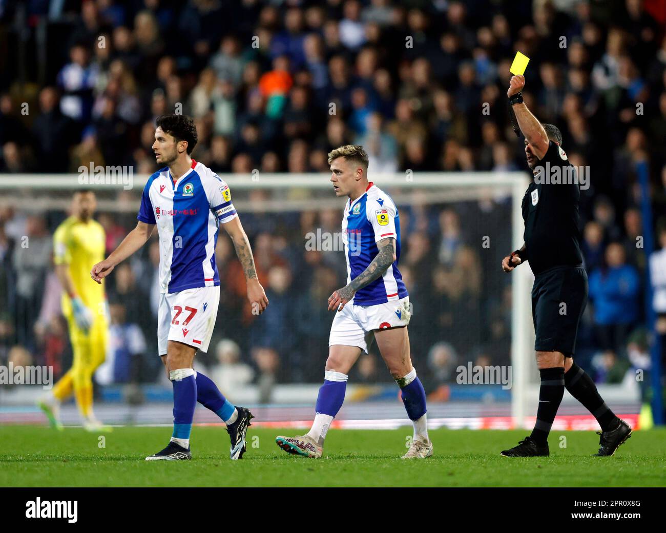 Referee Tim Robinson shows a yellow card to Blackburn Rovers' Sammie ...