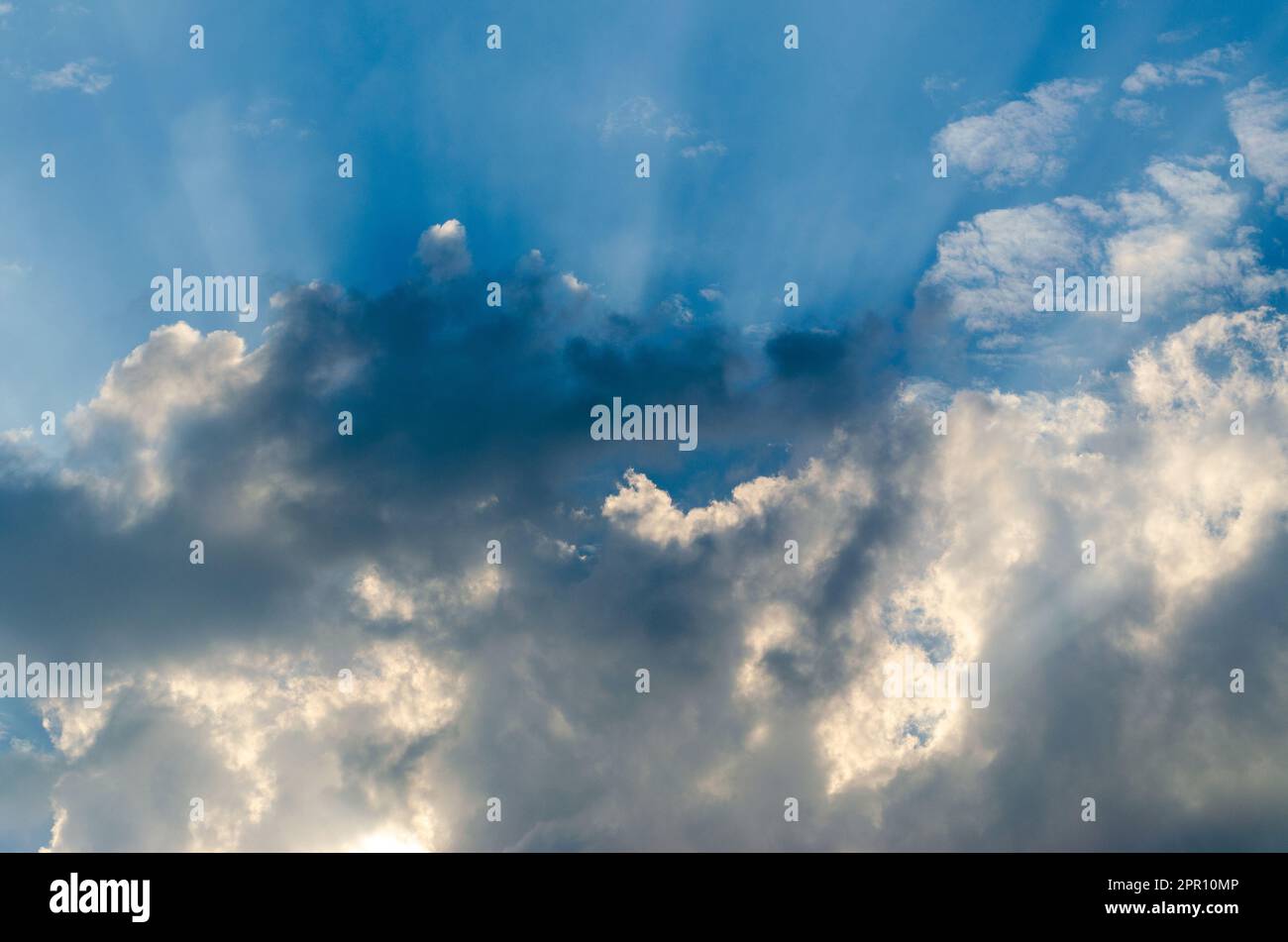 Sun rays through clouds in the blue morning sky Stock Photo - Alamy