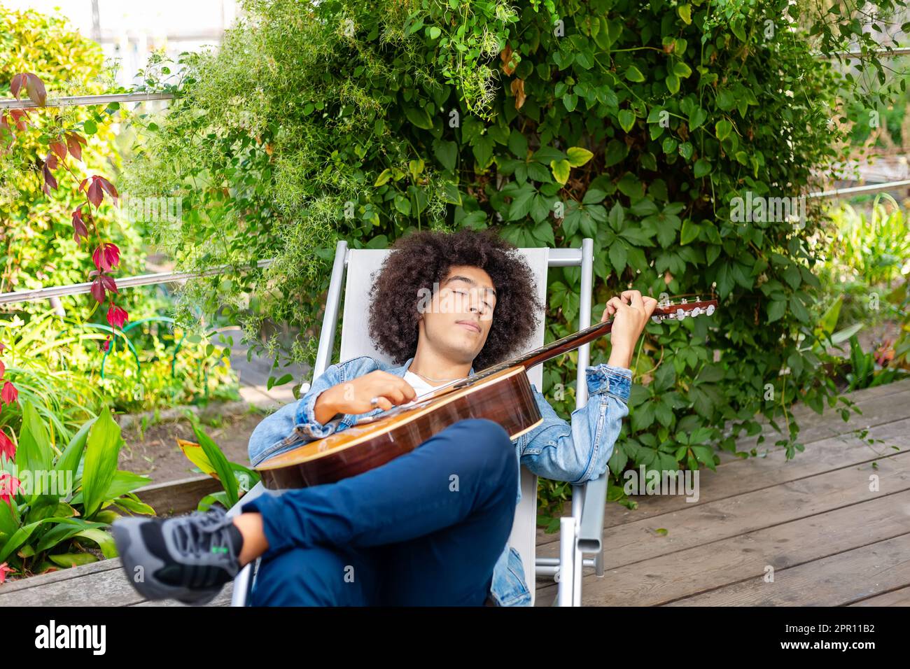 Beautiful young Afro-Italian mixed race man in casual wear playing ...