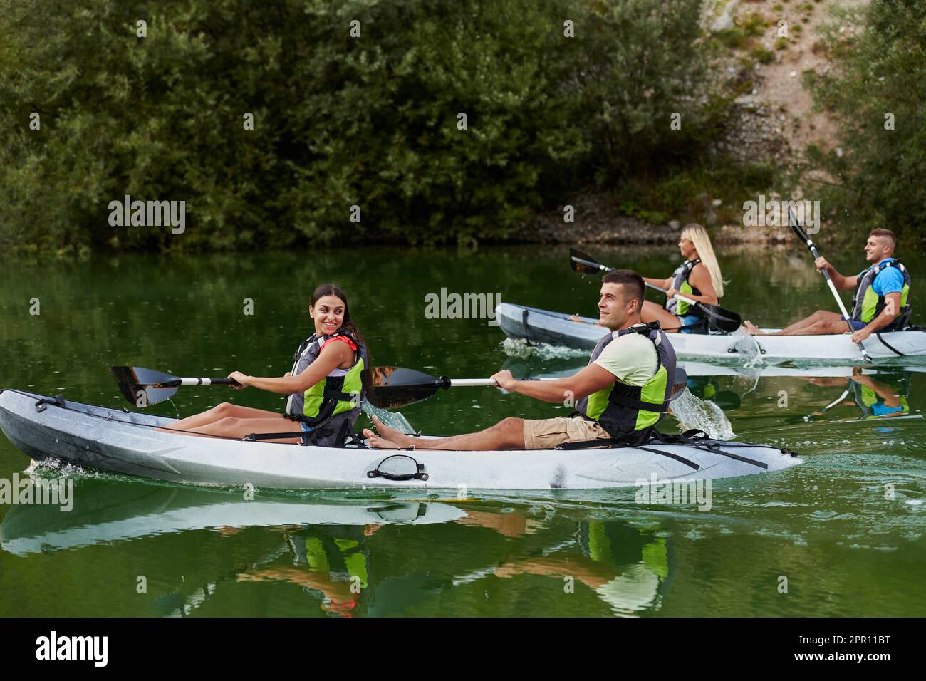 A group of friends enjoying having fun and kayaking while exploring the ...