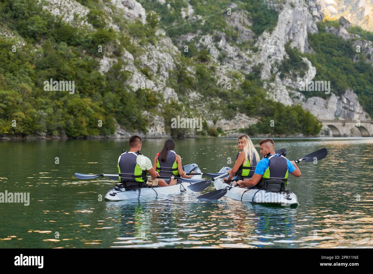 A group of friends enjoying having fun and kayaking while exploring the ...