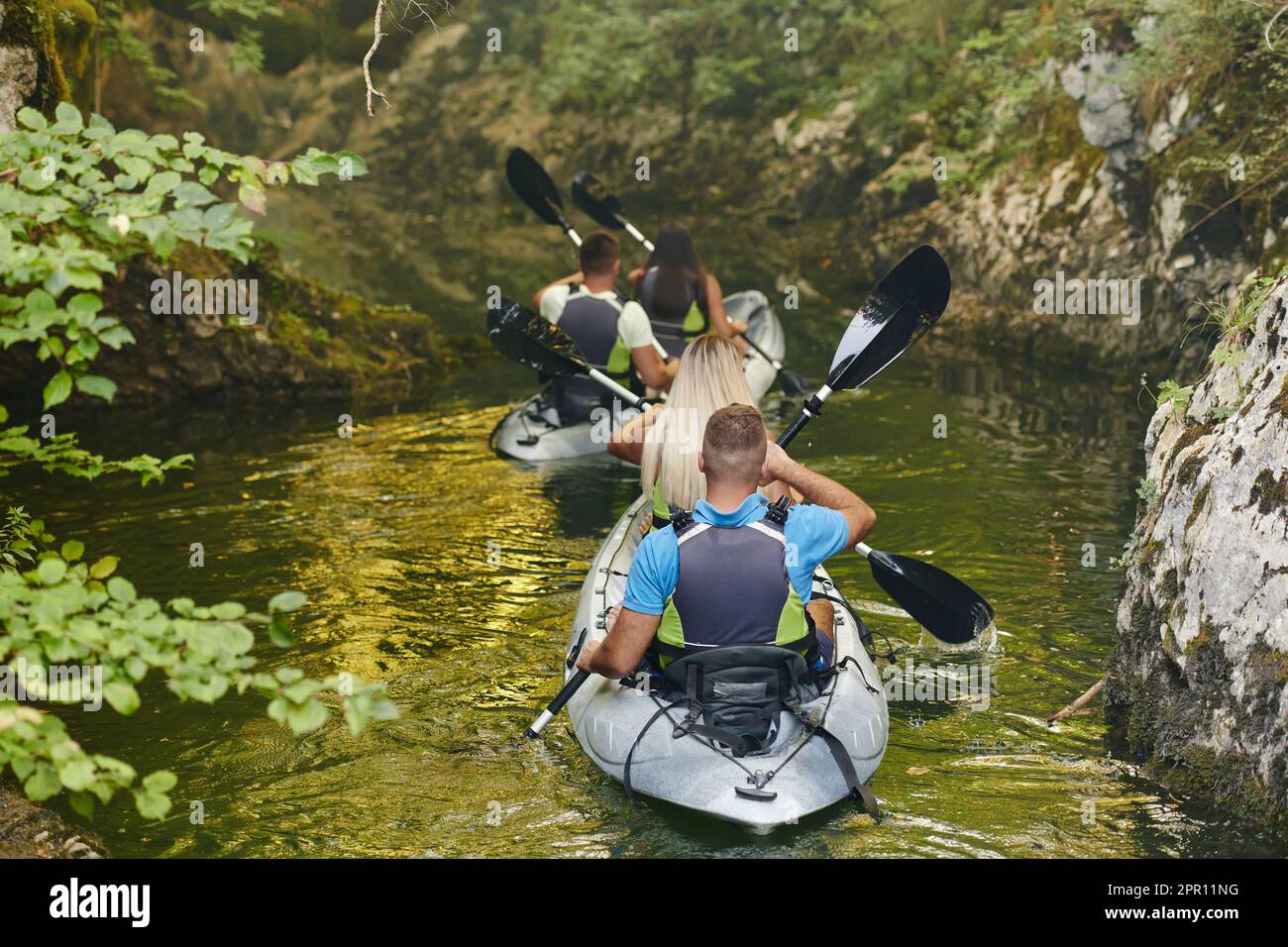 A group of friends enjoying having fun and kayaking while exploring the ...
