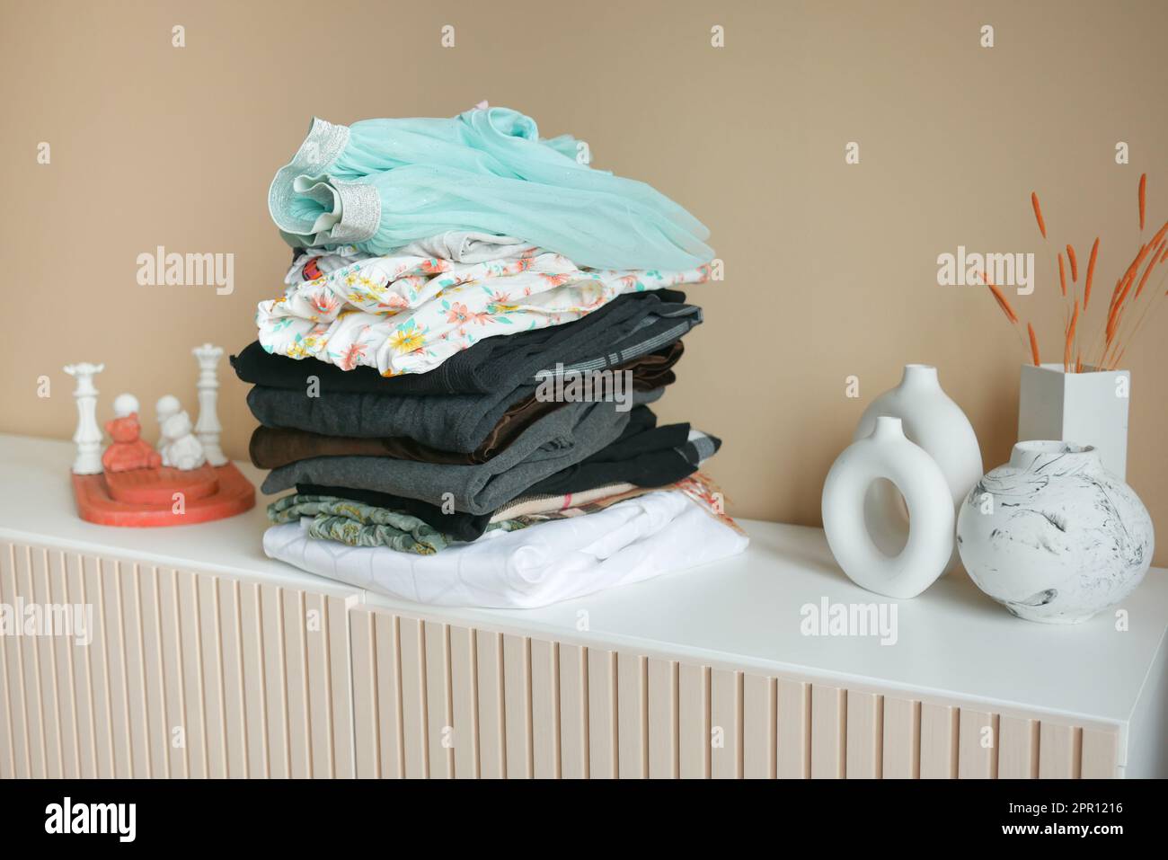 Stack of clothes on table indoor Stock Photo - Alamy