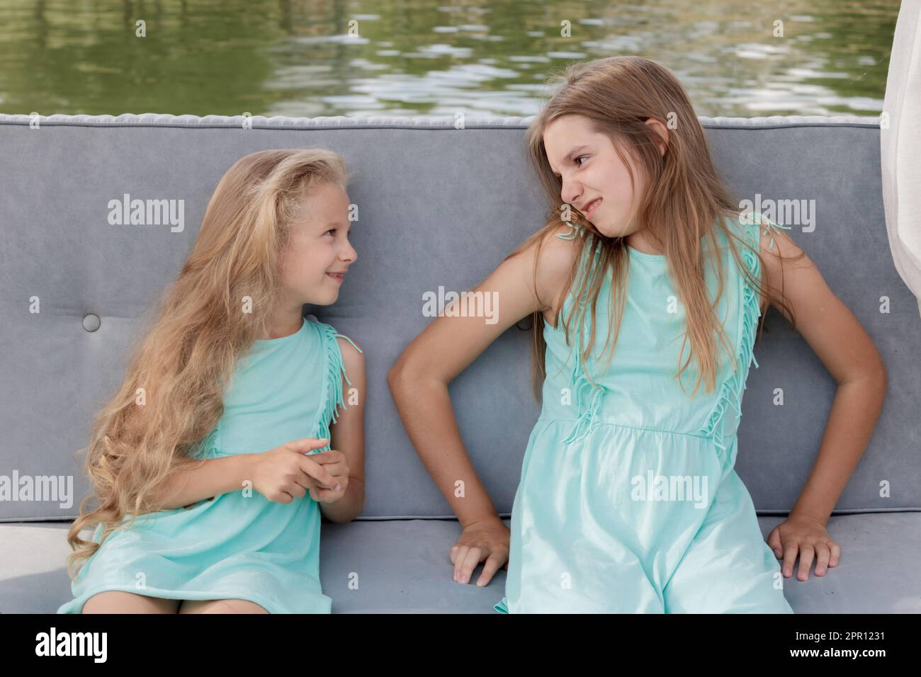 Two girls are sitting on a sofa by the sea, arguing and cursing ...