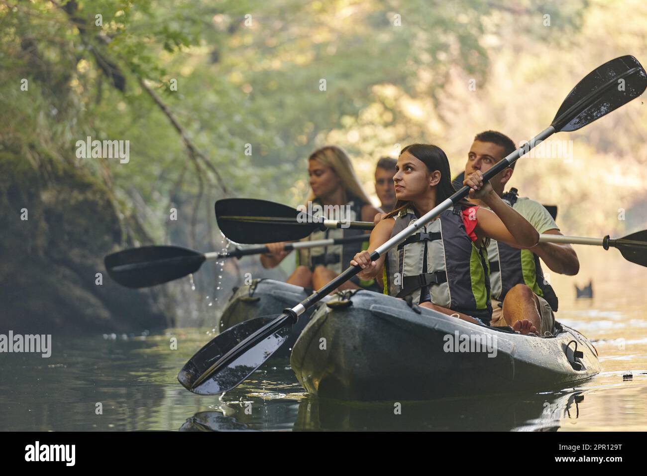 A group of friends enjoying having fun and kayaking while exploring the ...