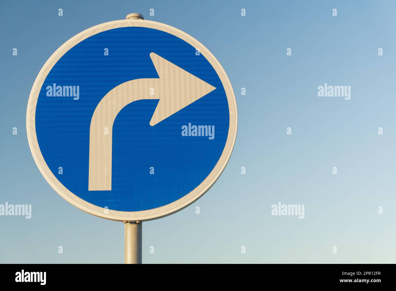 Road sign blue right turn signal on sky background close up Stock Photo - Alamy