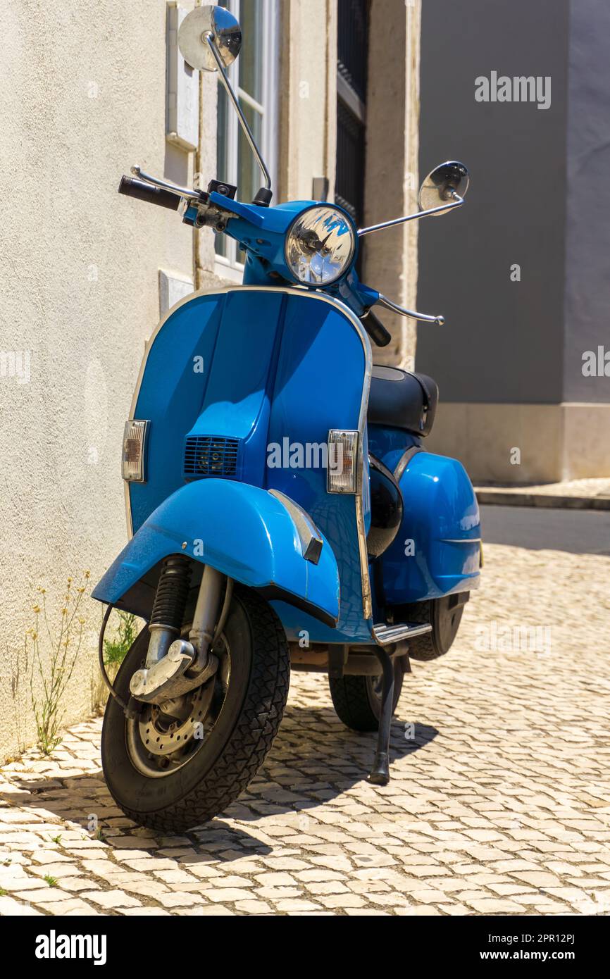 Bright blue moped parked on a European street close up Stock Photo - Alamy