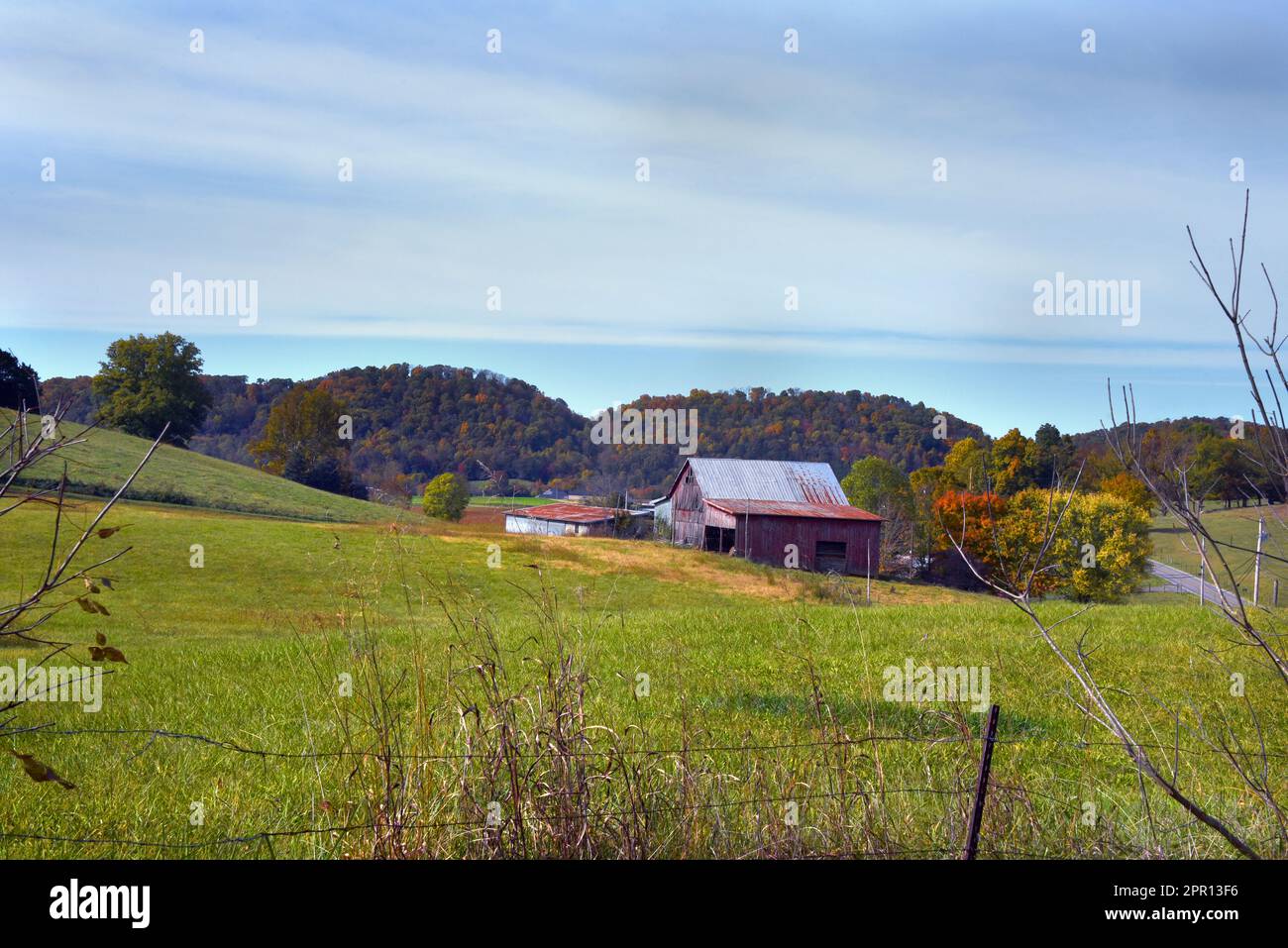 Appalachian Mountain farm has view of Autumn mountains. Road runs ...