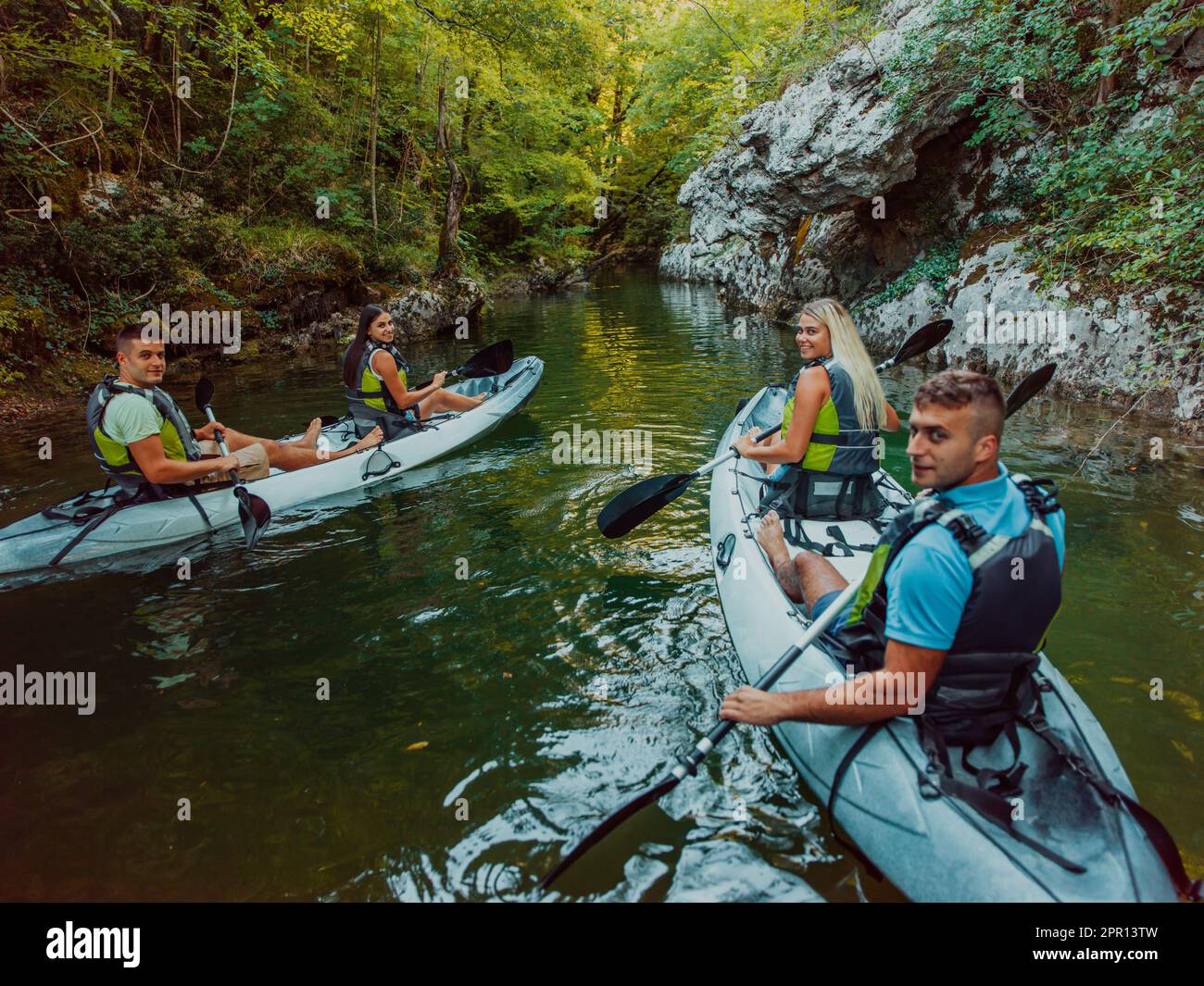 A group of friends enjoying having fun and kayaking while exploring the ...