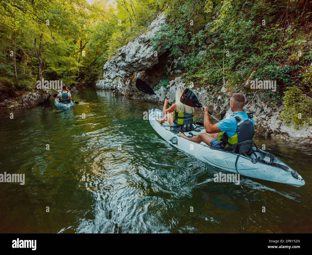 A group of friends enjoying having fun and kayaking while exploring the ...