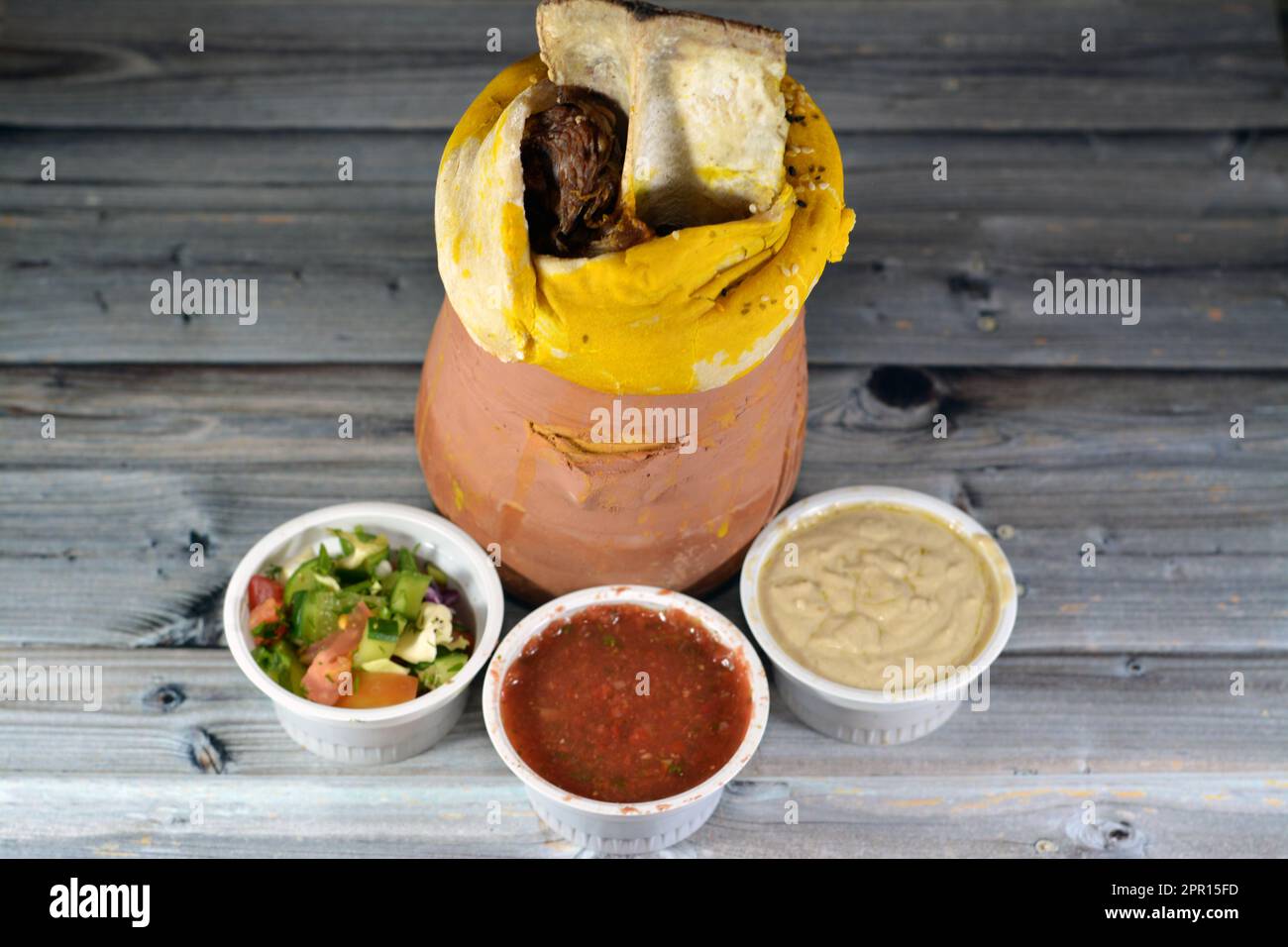 A pottery hot pot Jar covered with dough, sesame and lamb shank is ...