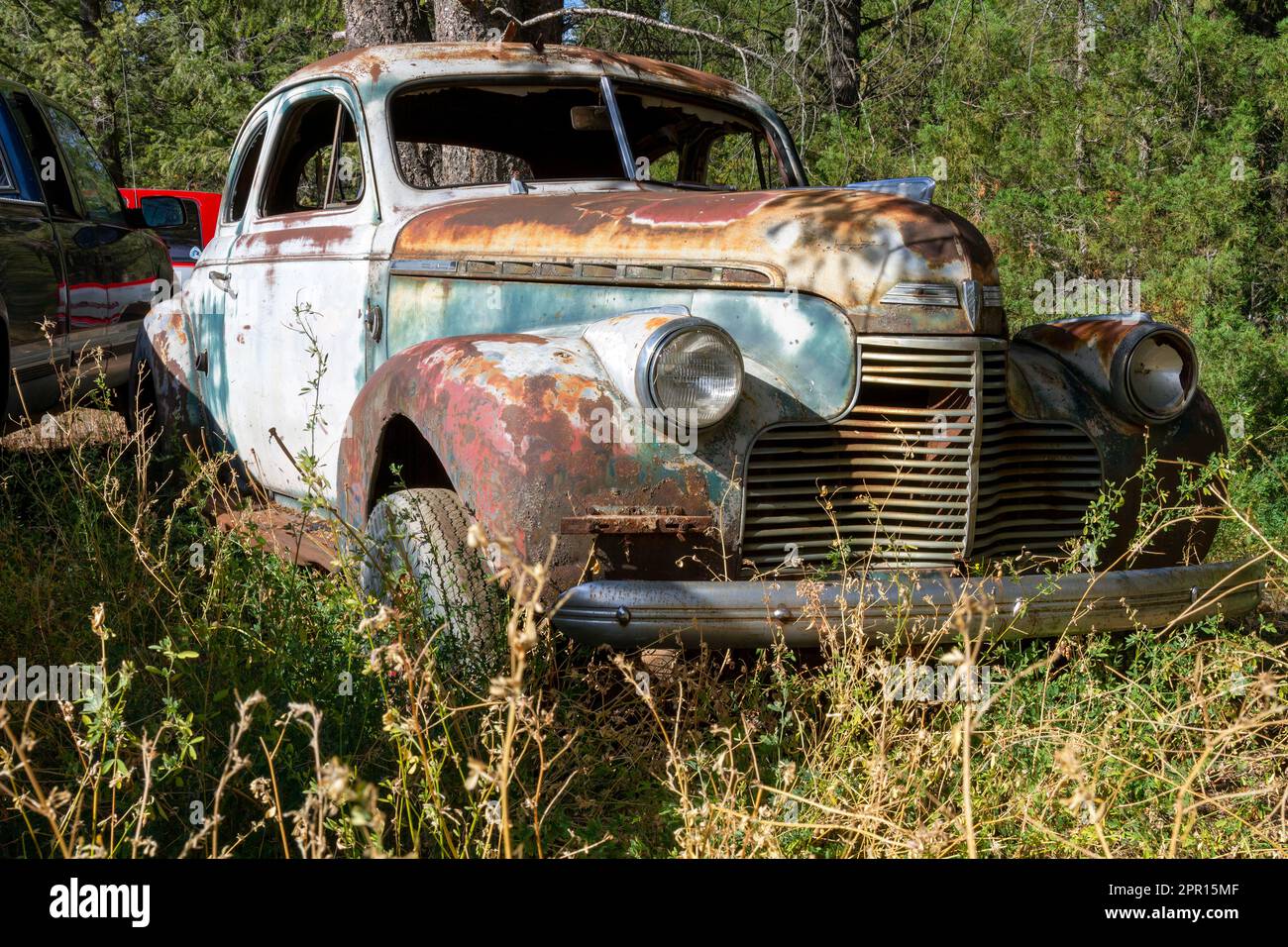 An old vintage abandoned decaying automobile in a field in British ...