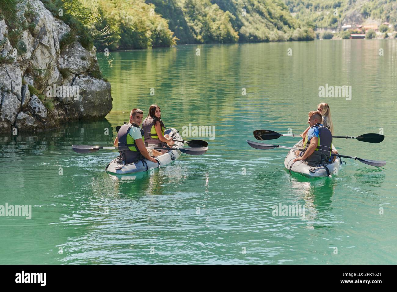 A group of friends enjoying having fun and kayaking while exploring the ...