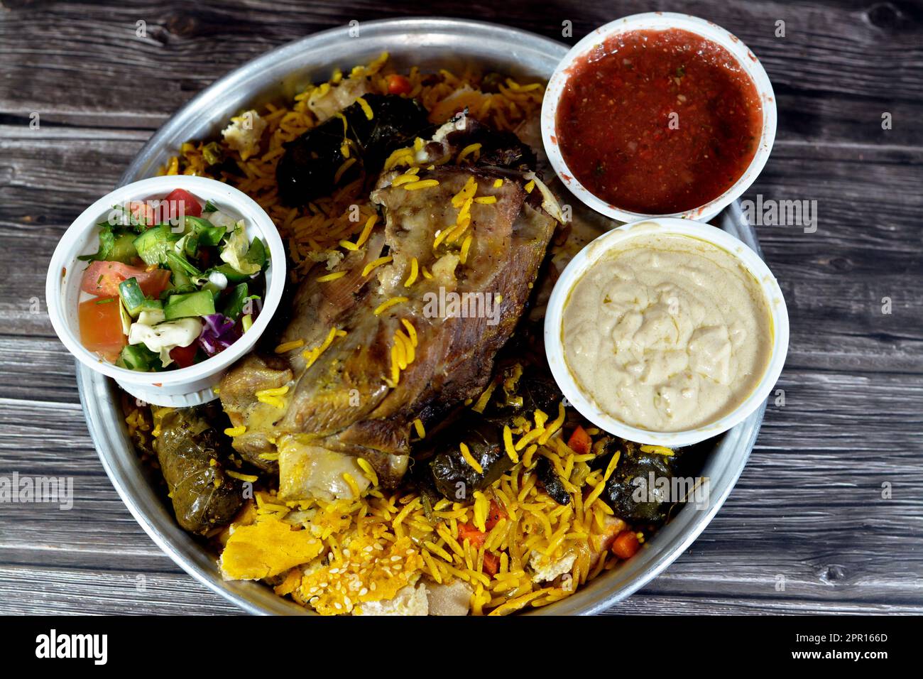 A well cooked lamb shank with yellow Basmati rice and mixed vegetables ...
