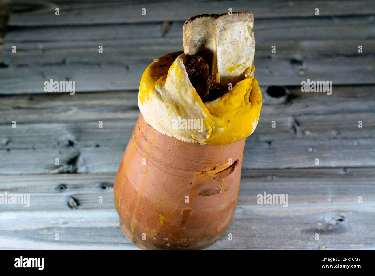 A pottery hot pot Jar covered with dough, sesame and lamb shank is ...