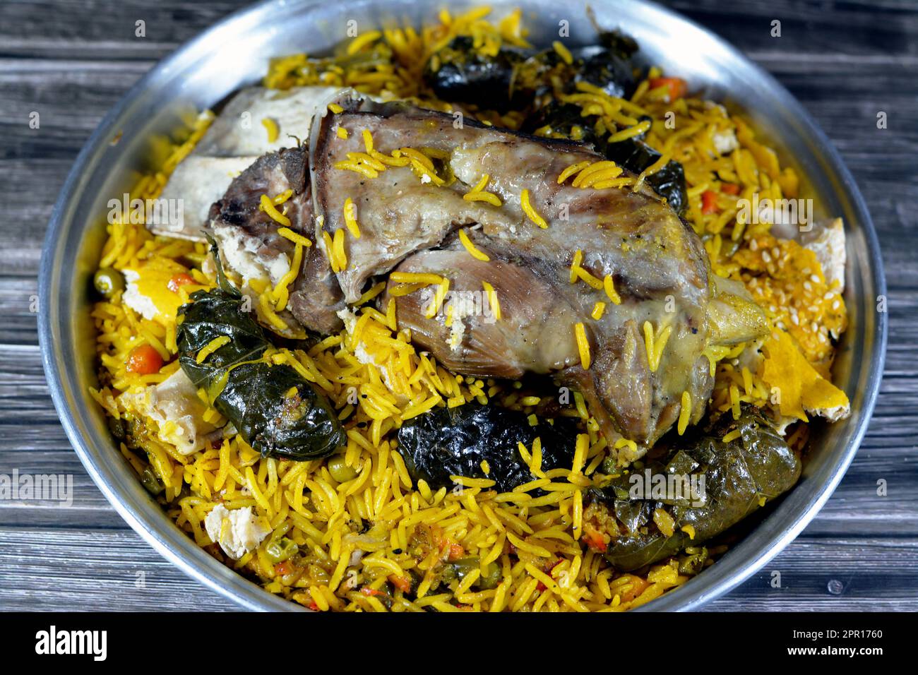A well cooked lamb shank with yellow Basmati rice and mixed vegetables ...