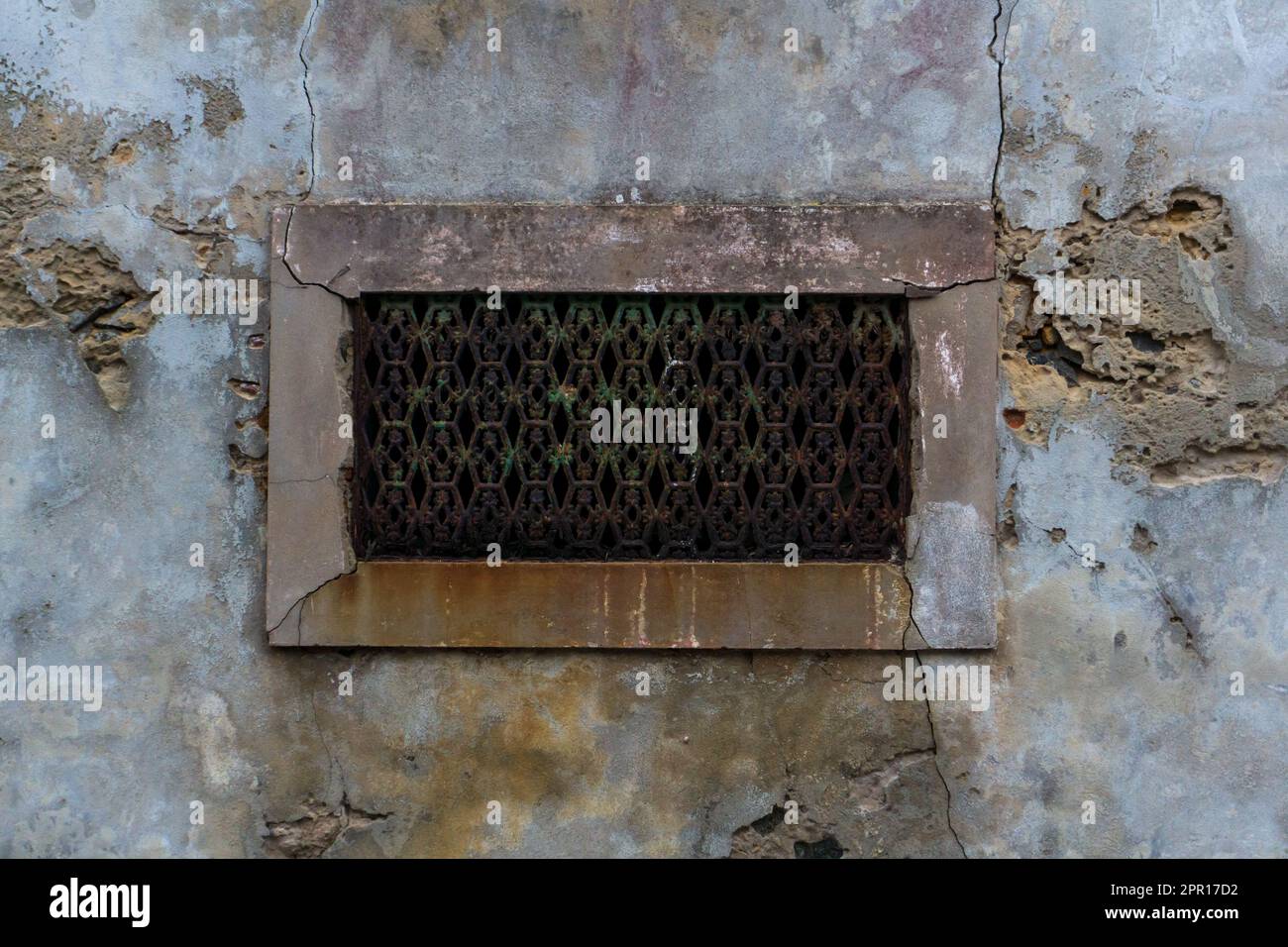Antique rusty metal grille on a small window in the wall Stock Photo ...