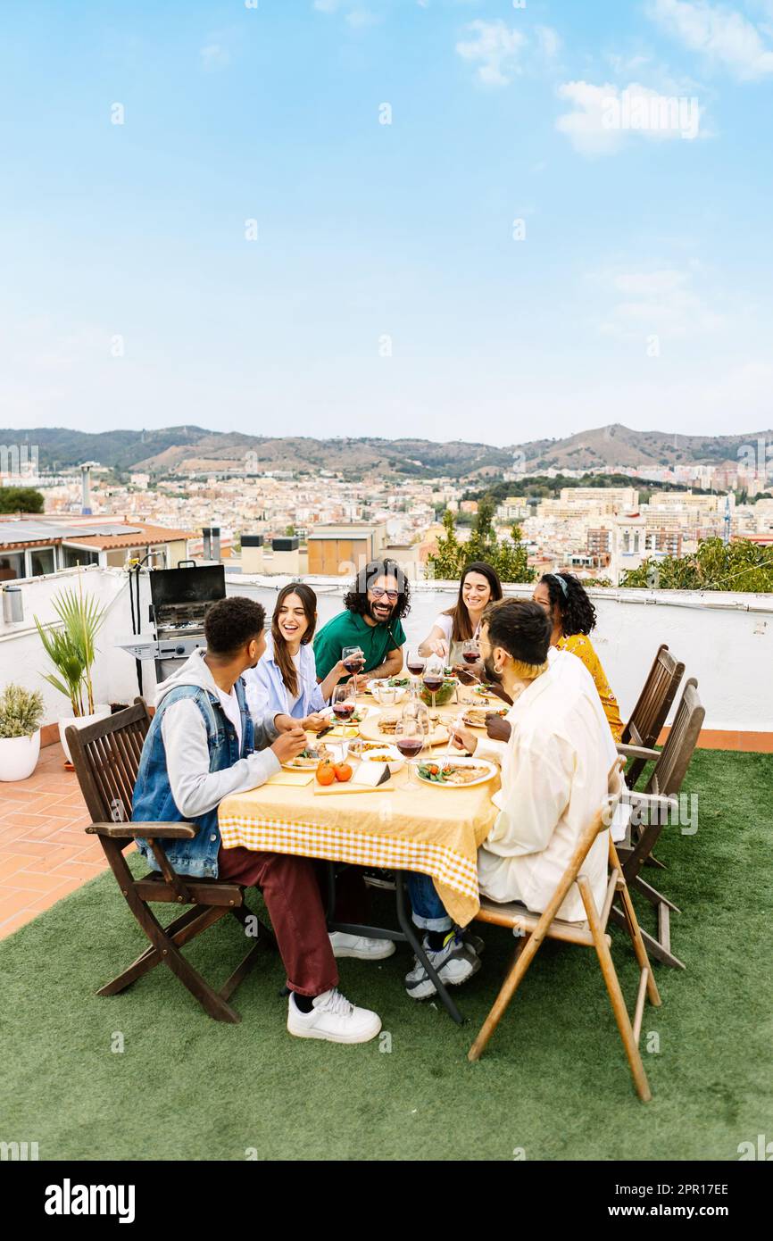 Vertical photo of a gathering of young friends having fun at barbecue ...
