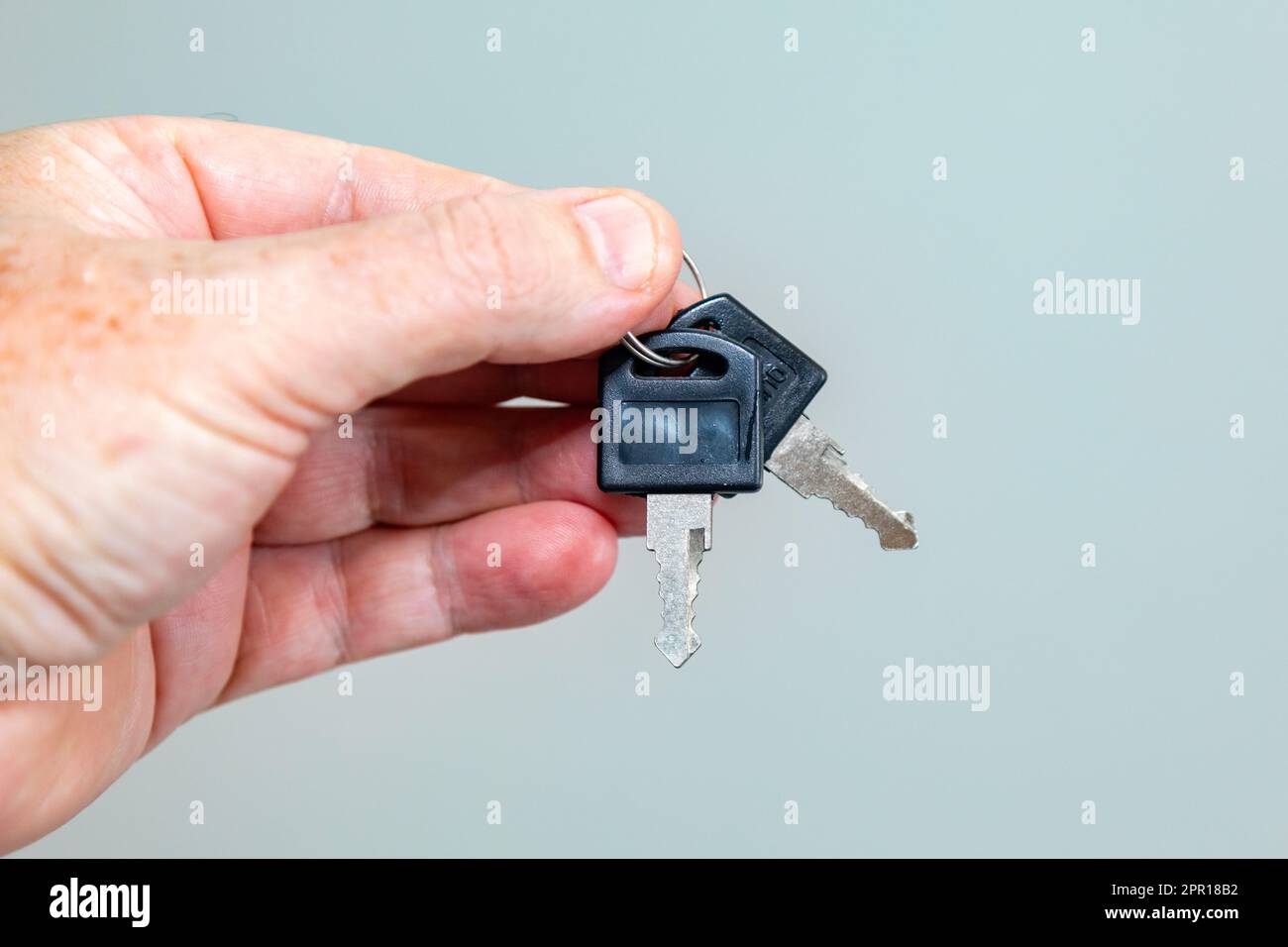 Male hand holding traditional keys Stock Photo - Alamy