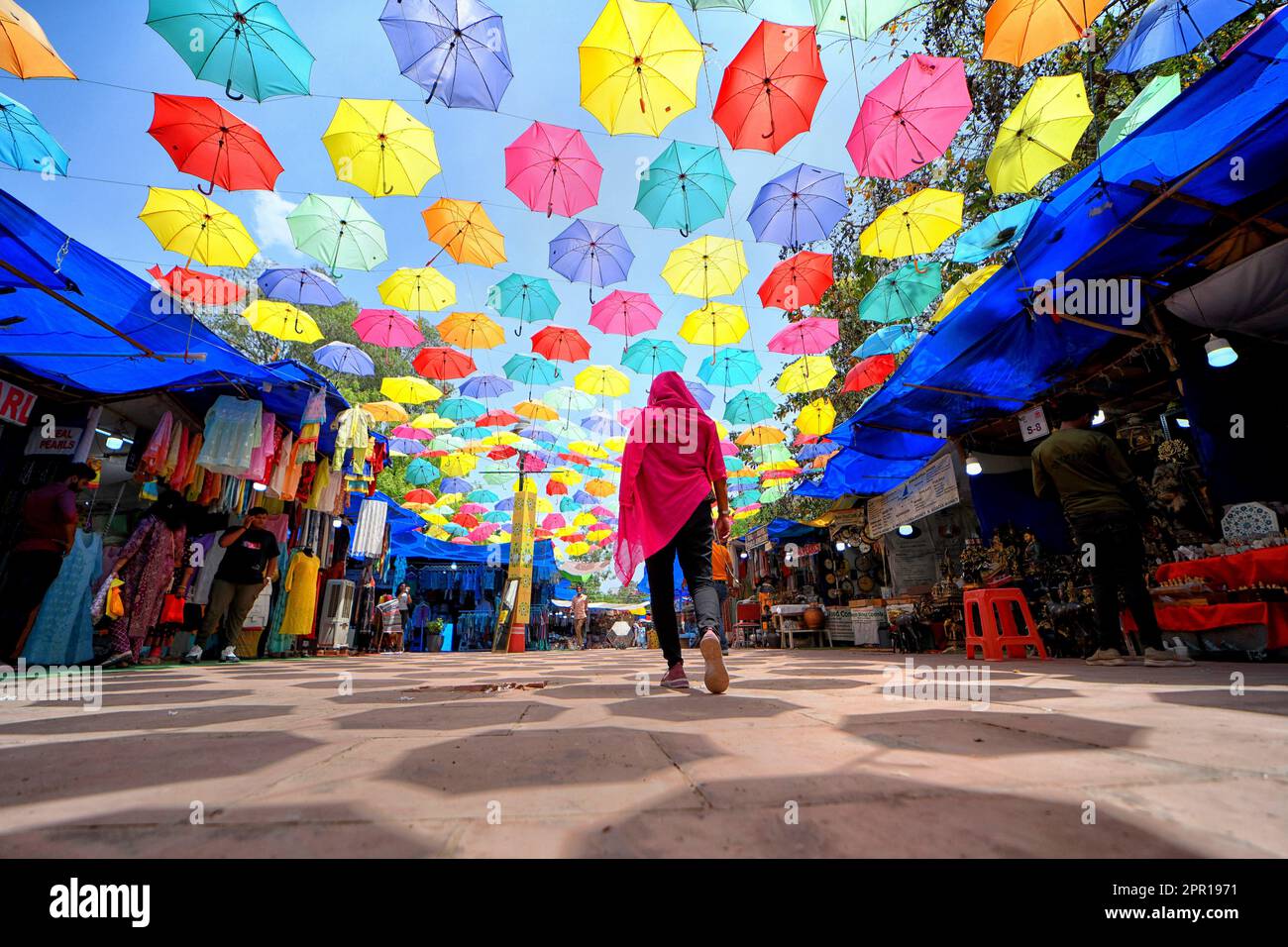 Delhi, India. 21st Apr, 2023. A woman walks under the Colorful Umbrella ...