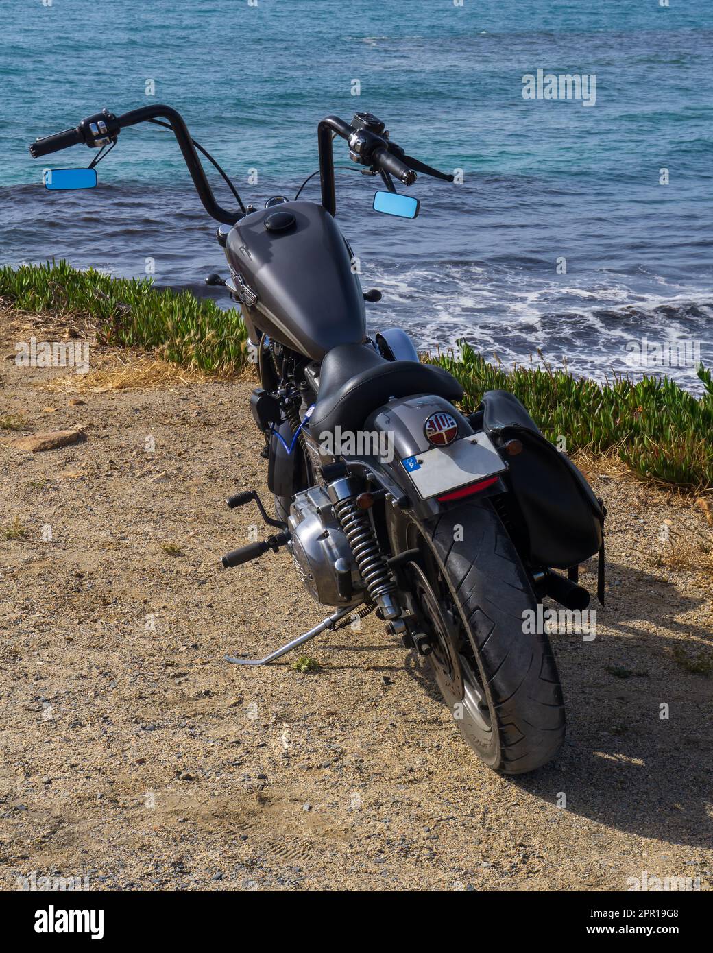 A black classic motorcycle stands on a cliff above the ocean Stock ...