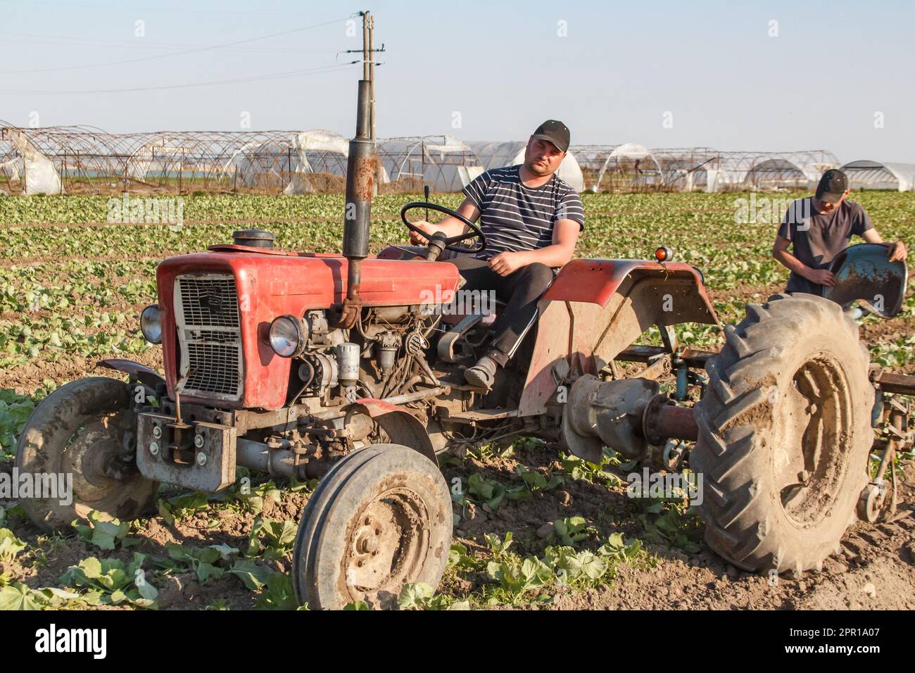 farmers working in the field plowing soil using a tractor Stock Photo ...