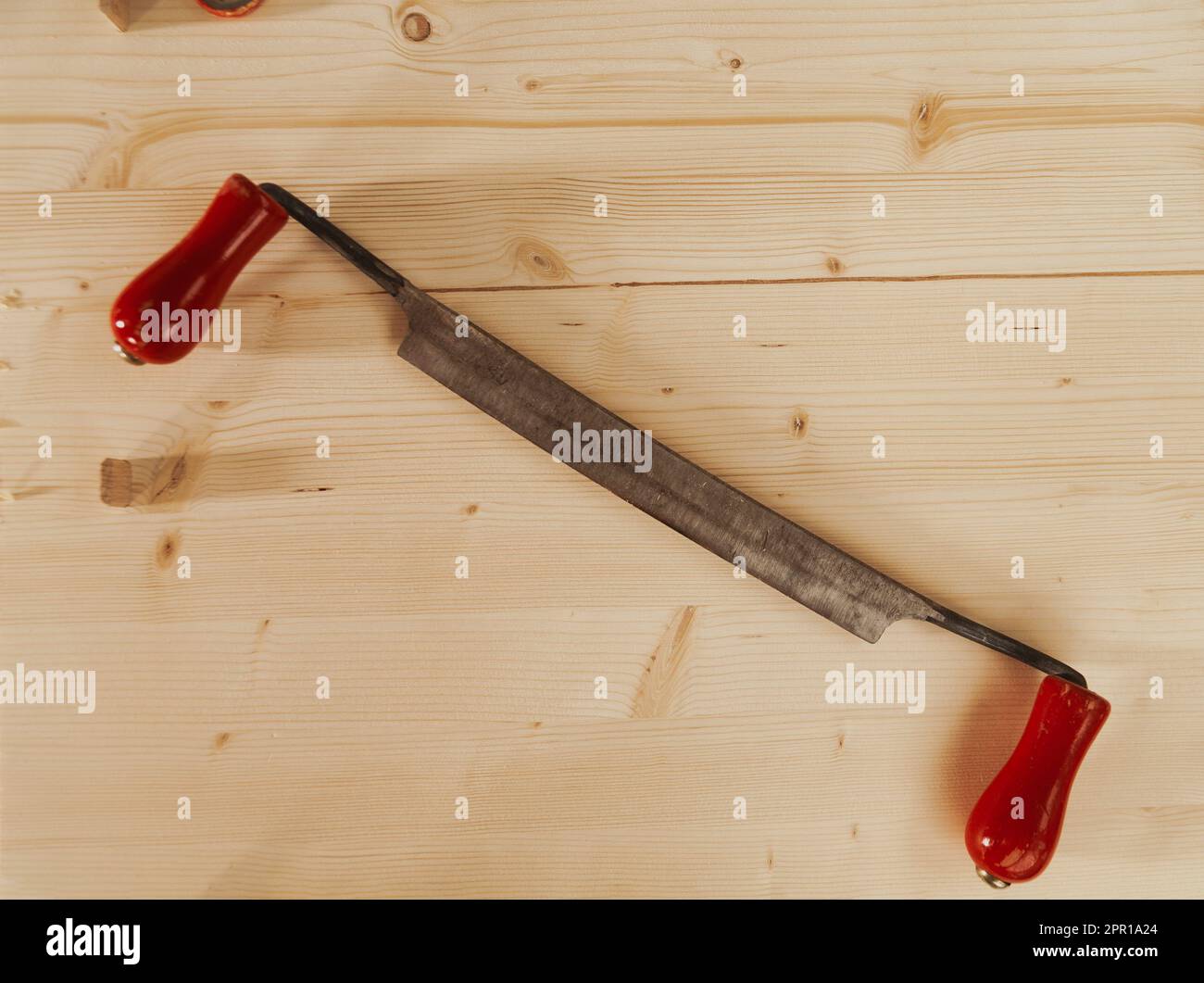 Top view shot of a carpenter's hand cutting tool. The drawknife has ...