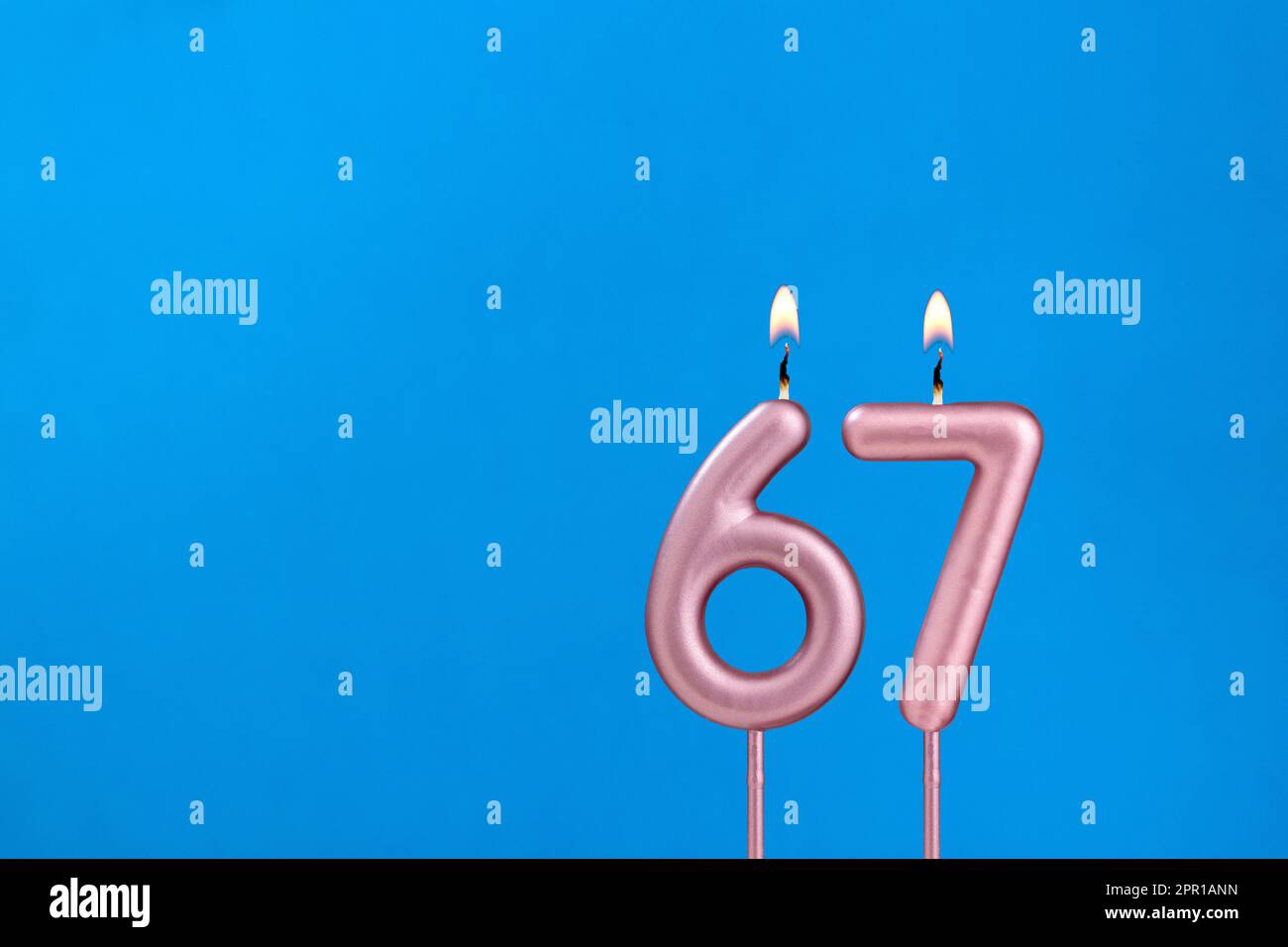Number 67 - Burning anniversary candle on blue foamy background Stock ...